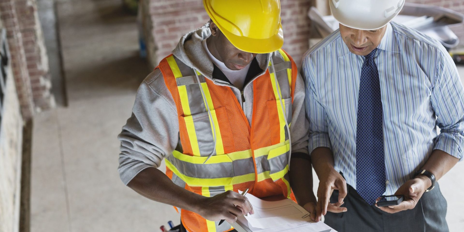 high-angle-view-of-tradesman-and-architect-discussing-work-order-at ...